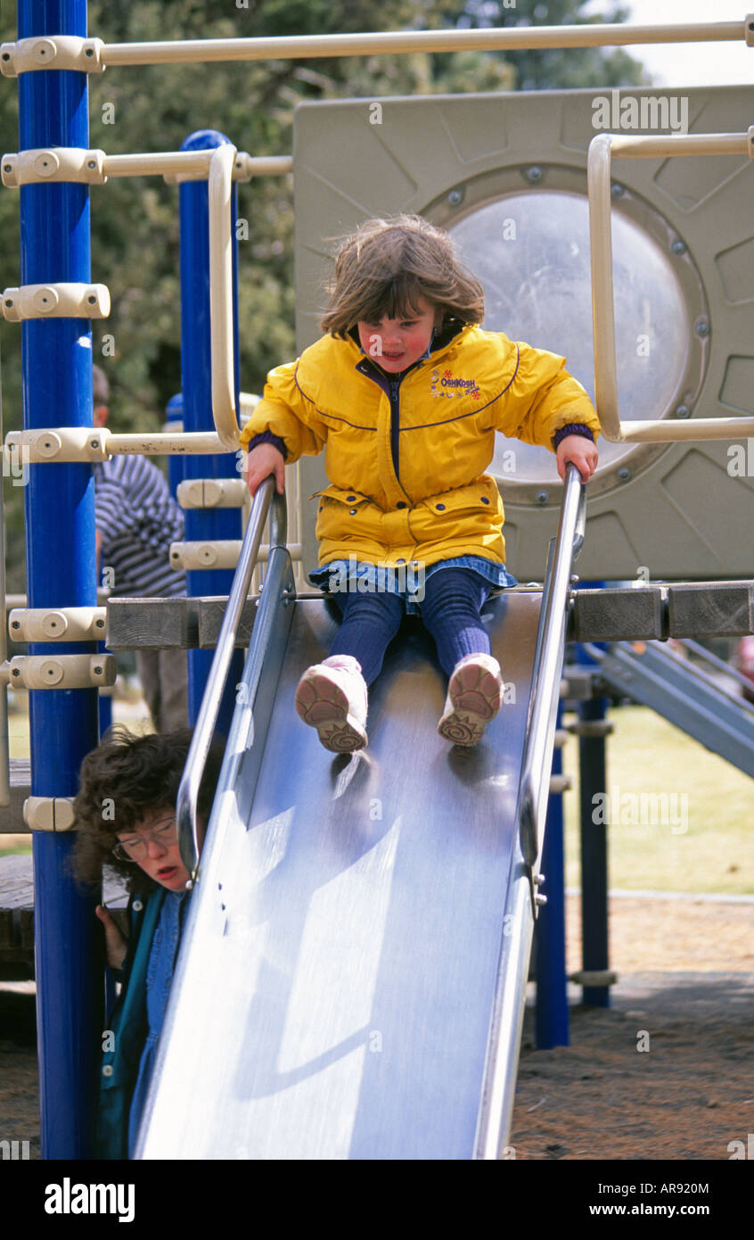 A young girl on a playground slide in a city park in Bend Oregon in ...