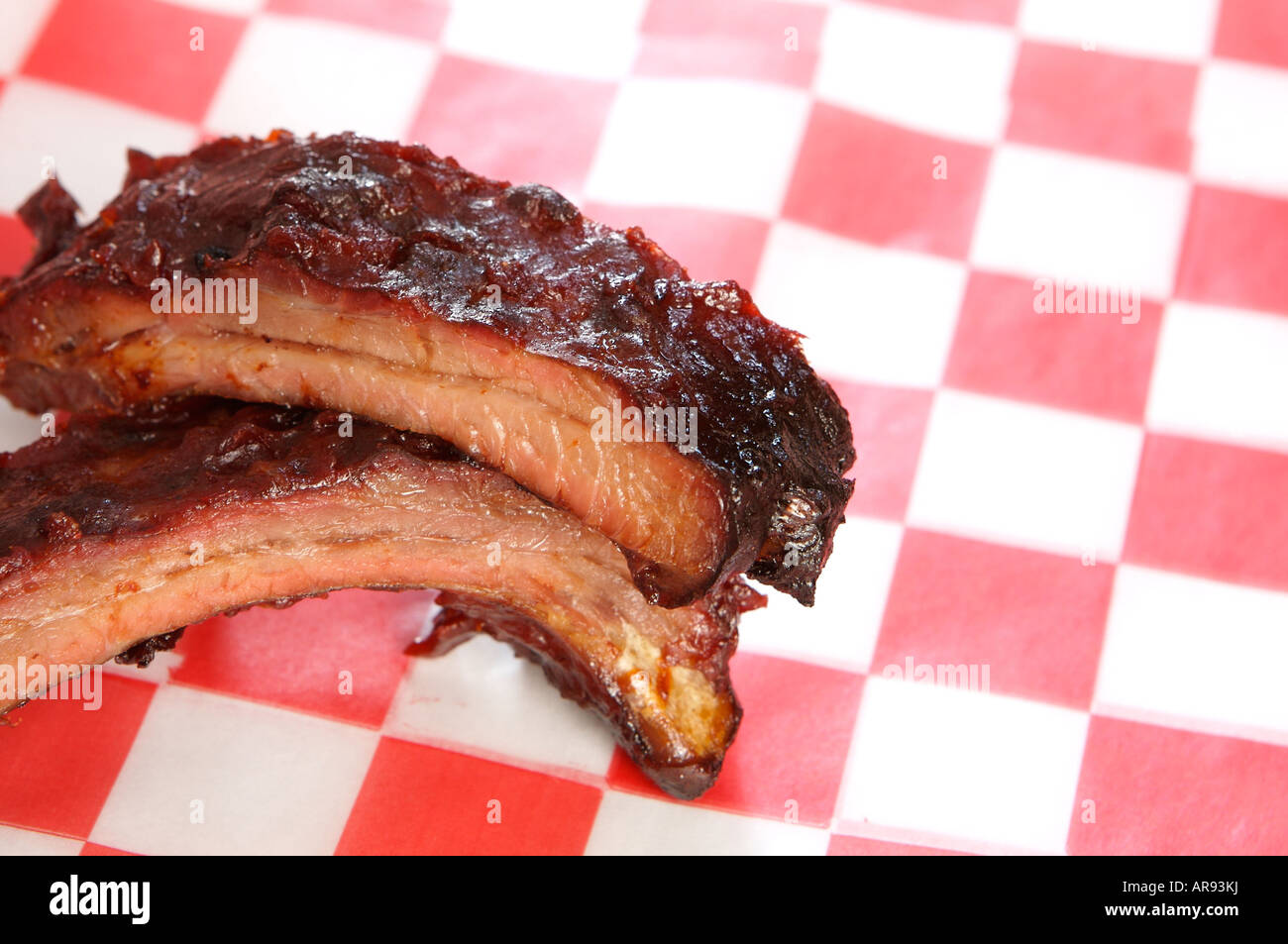 Babyback spare barbeque pork ribs on a checkered restaurant tissue ...