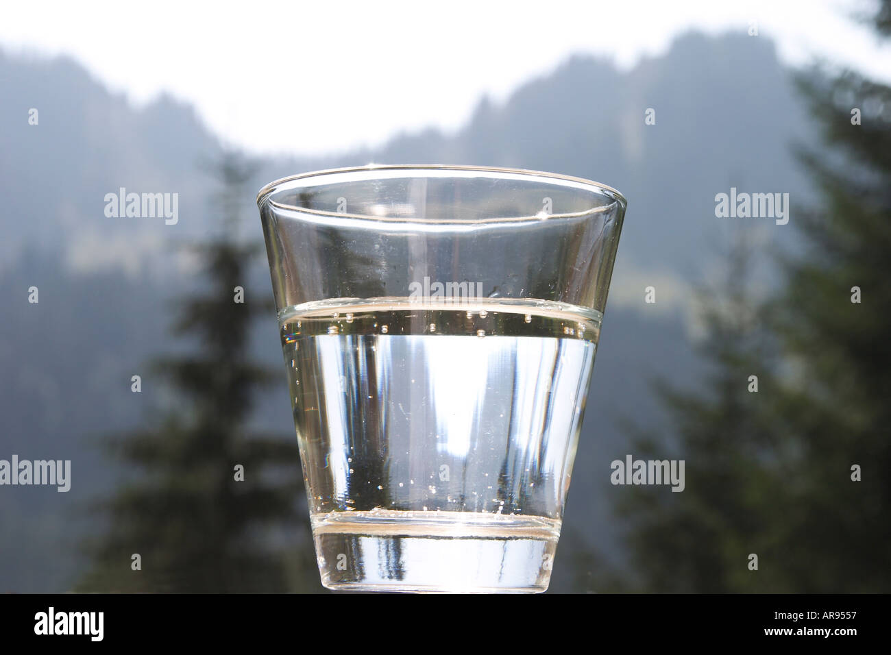Waterglas in front of mountain panorama Stock Photo - Alamy