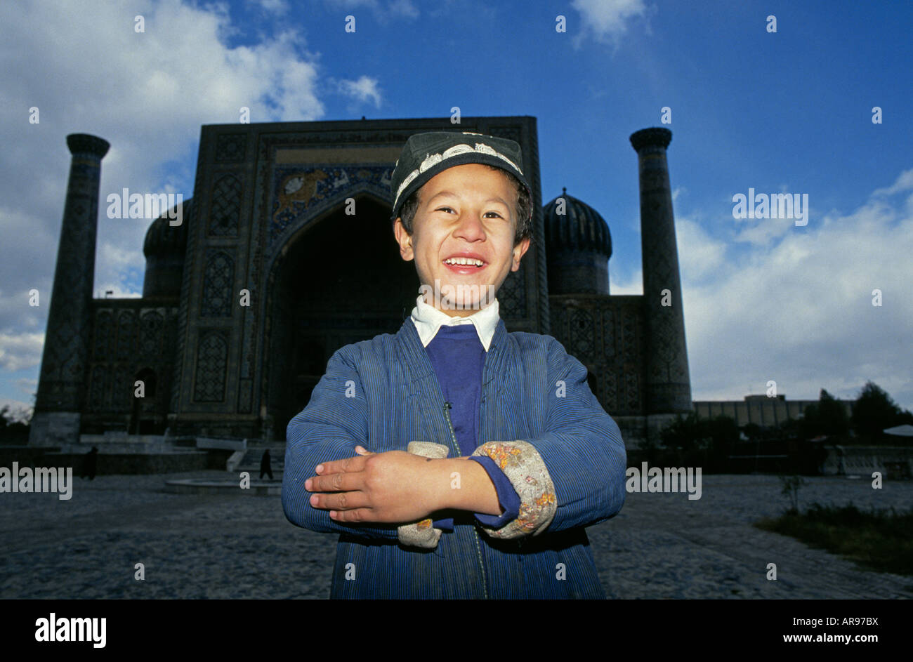 A young Muslim Uzbek boy in traditional clothing in front of a ...