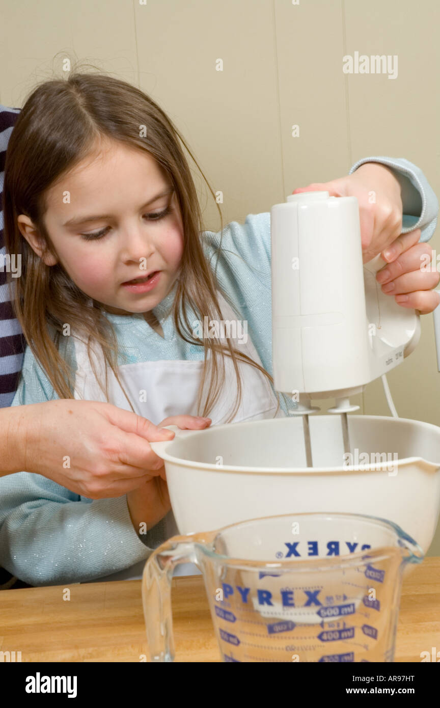 Little girl operating the mixer for baking Stock Photo - Alamy