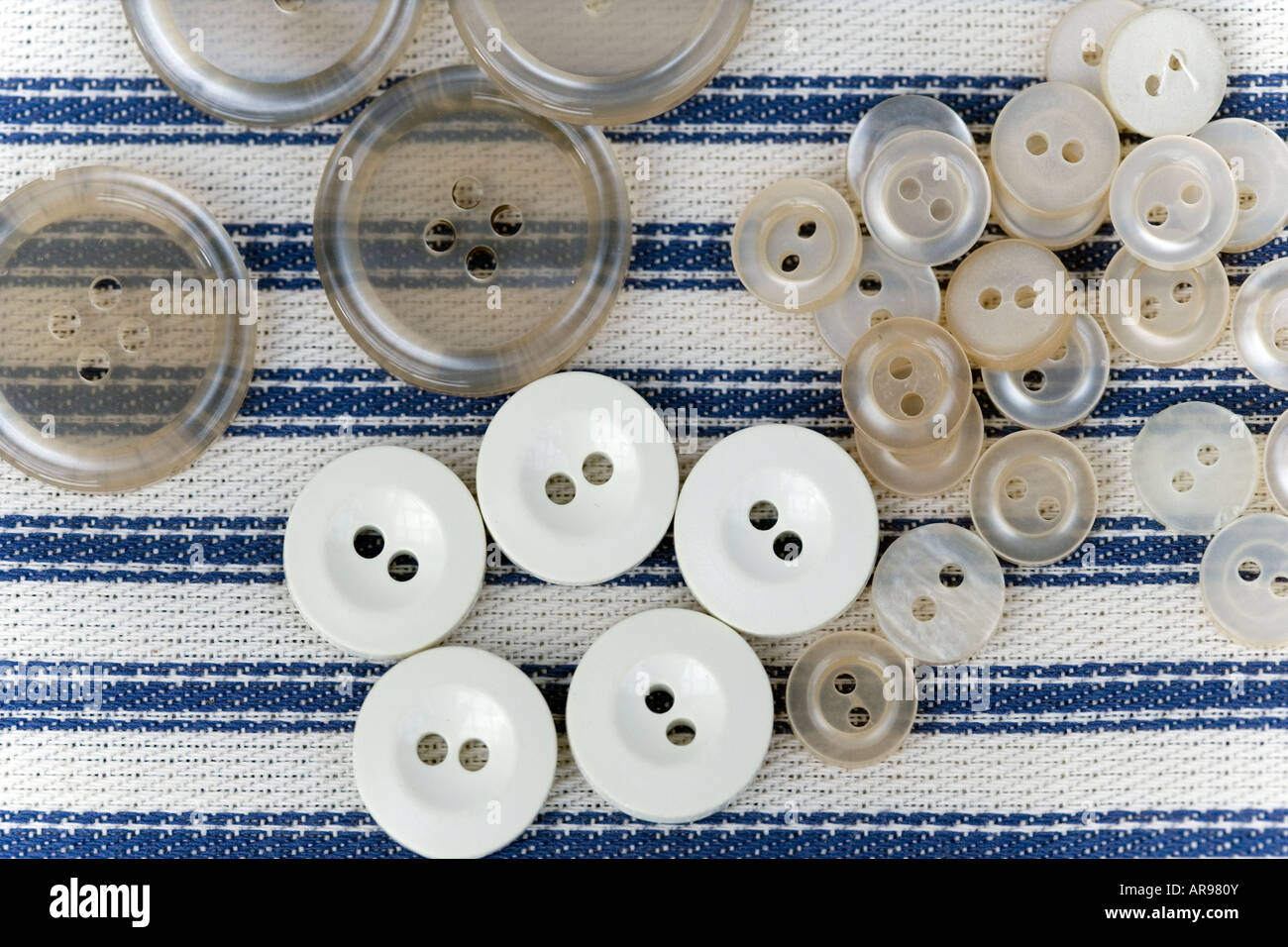 A collection of vintage white buttons shot on a traditional stripy ...
