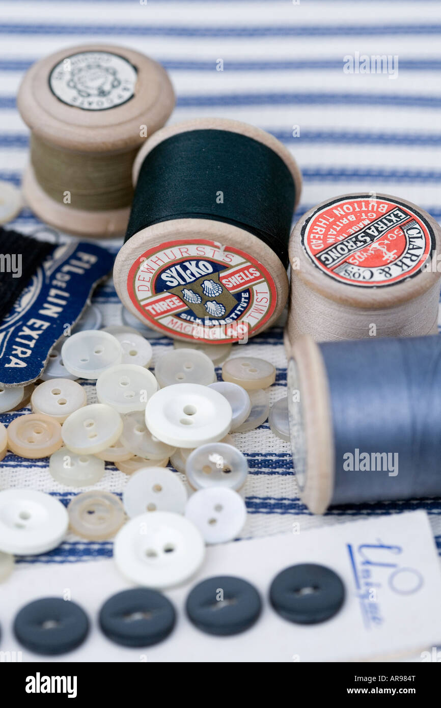 Vintage wooden cotton reels and used buttons on traditional linen ...