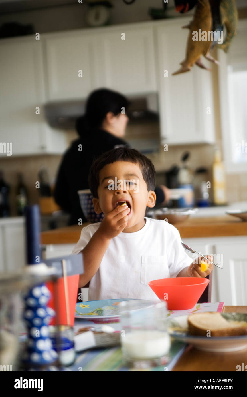 Young cute boy eating breakfast Stock Photo - Alamy