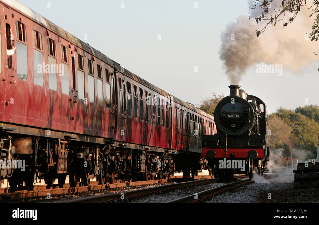 A steam locomotive travels past a set of carriages Stock Photo - Alamy