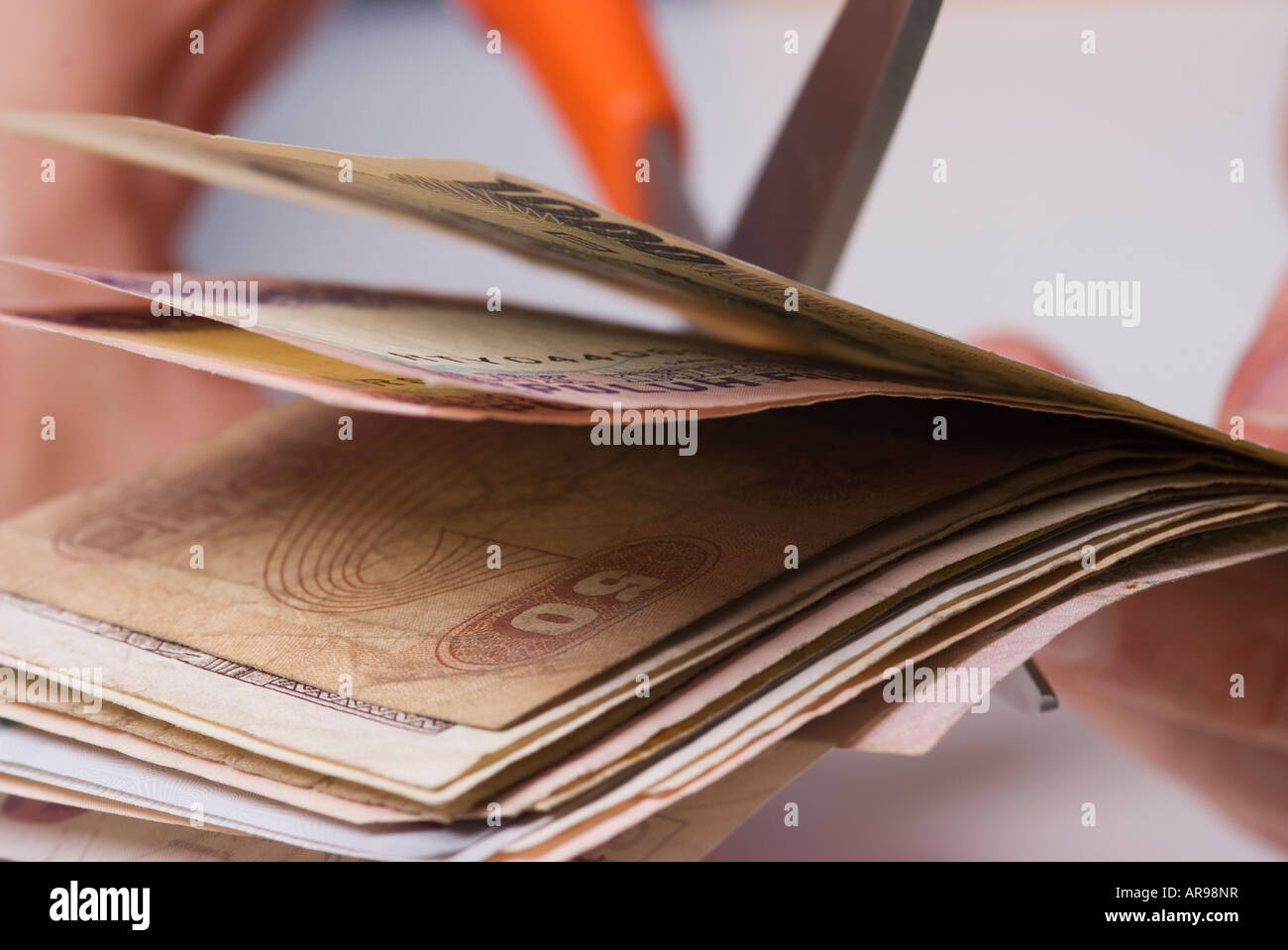 Close up shot of bank notes being cut with scissors Stock Photo - Alamy