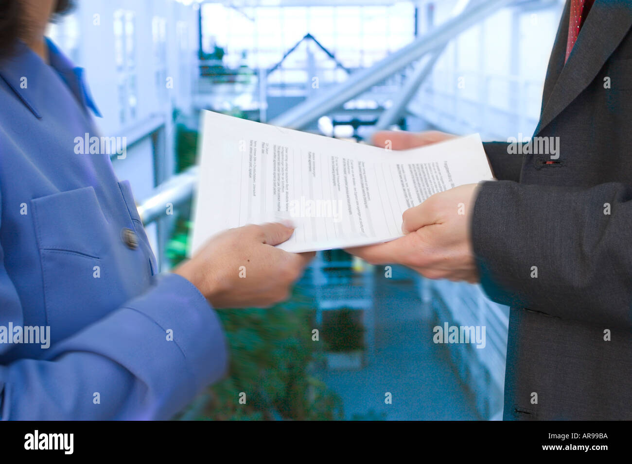 Man hands over documents to woman Stock Photo - Alamy
