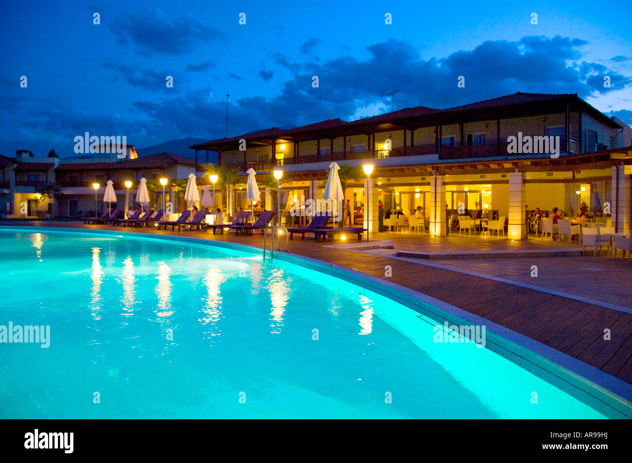 Pool area with blue lounge chairs at dusk at the Dion Palace Resort in ...