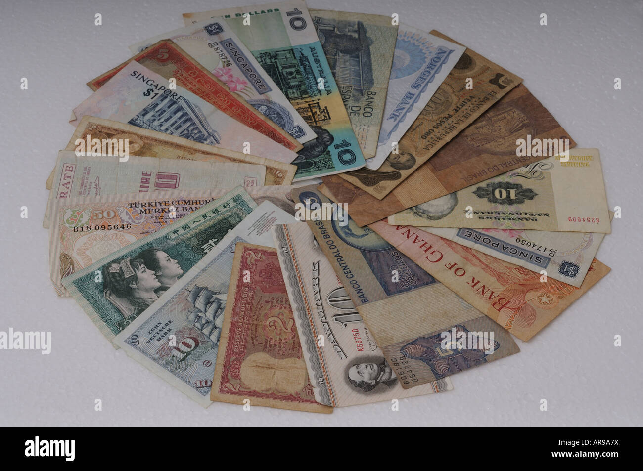 Used and dirty bank notes from five continents spread out in a circle ...