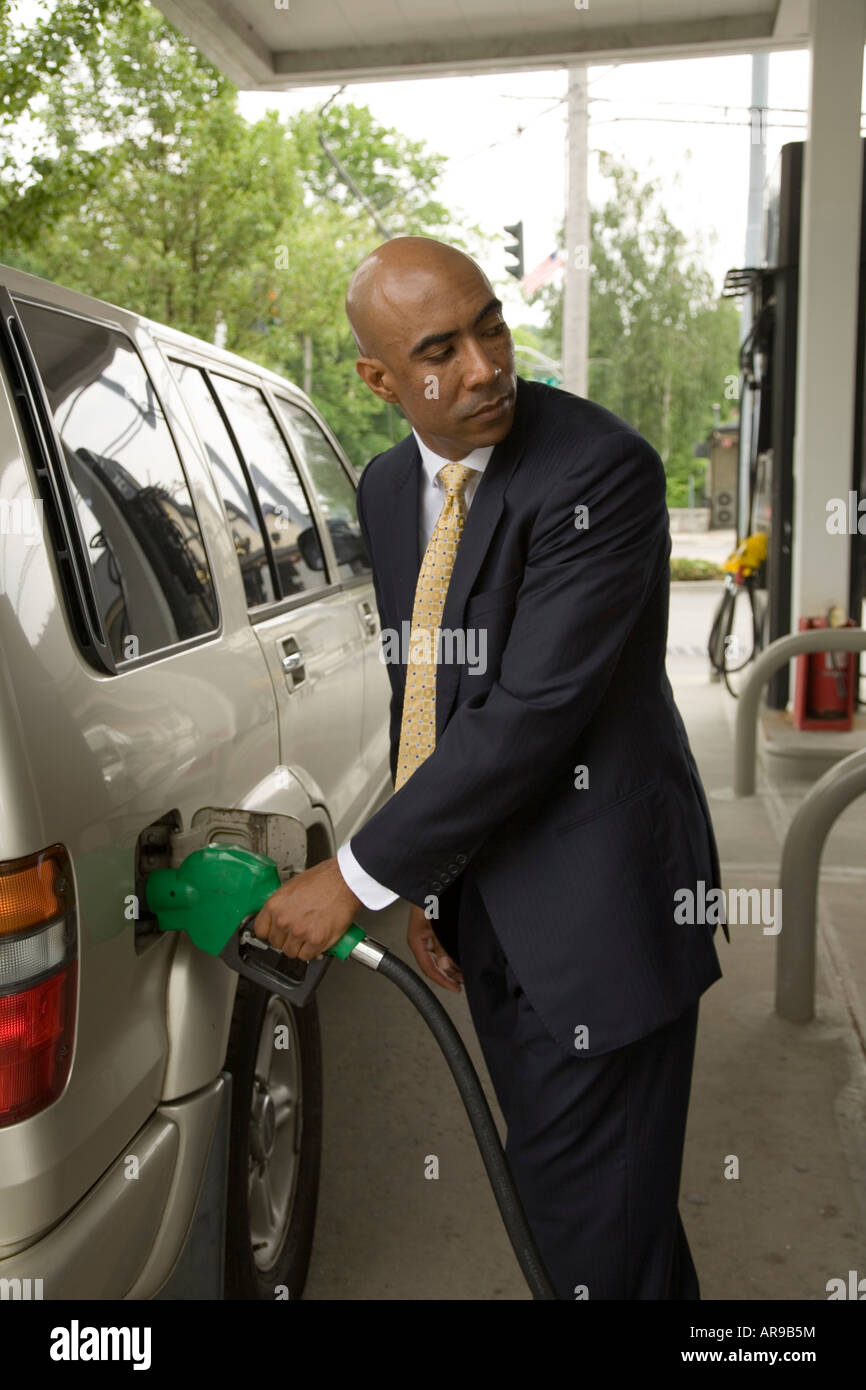 African American businessman pumping gas into his SUV Stock Photo - Alamy