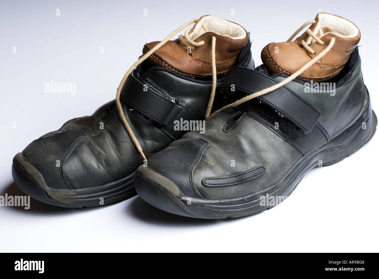 Image of baby shoes inside an adult shoe Stock Photo - Alamy