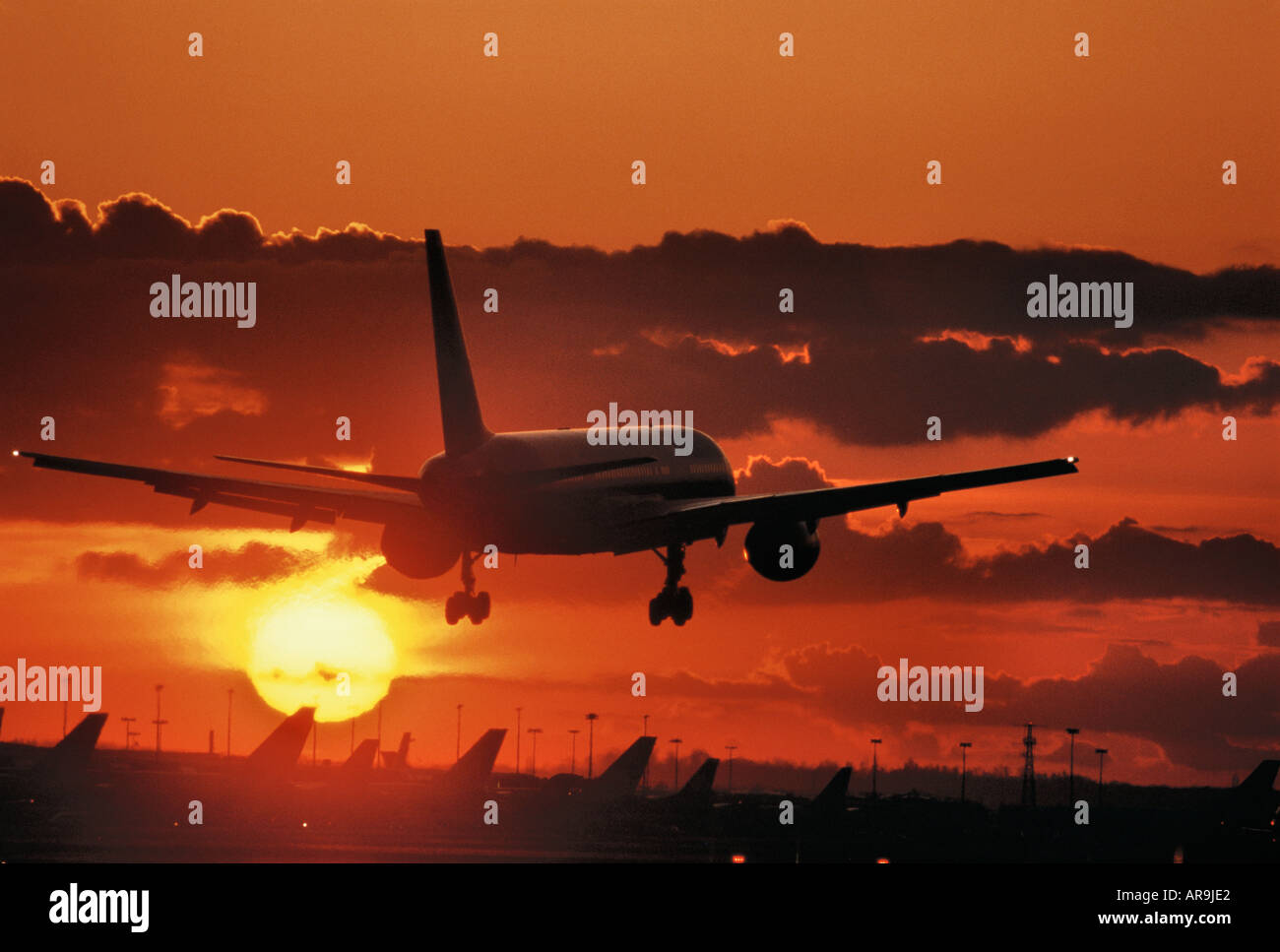 Boeing 757 jet in the air heading into an golden orange sky at sunset ...