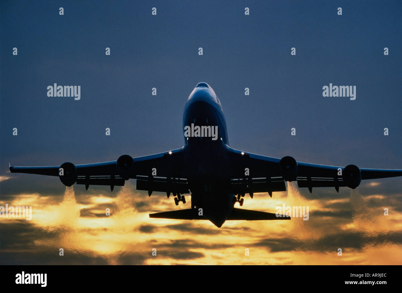 airliner Boeing 747 jumbo jet in the air on take off in an golden ...