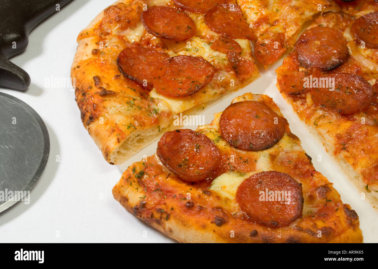 Pepperoni Pizza with cutter Stock Photo - Alamy