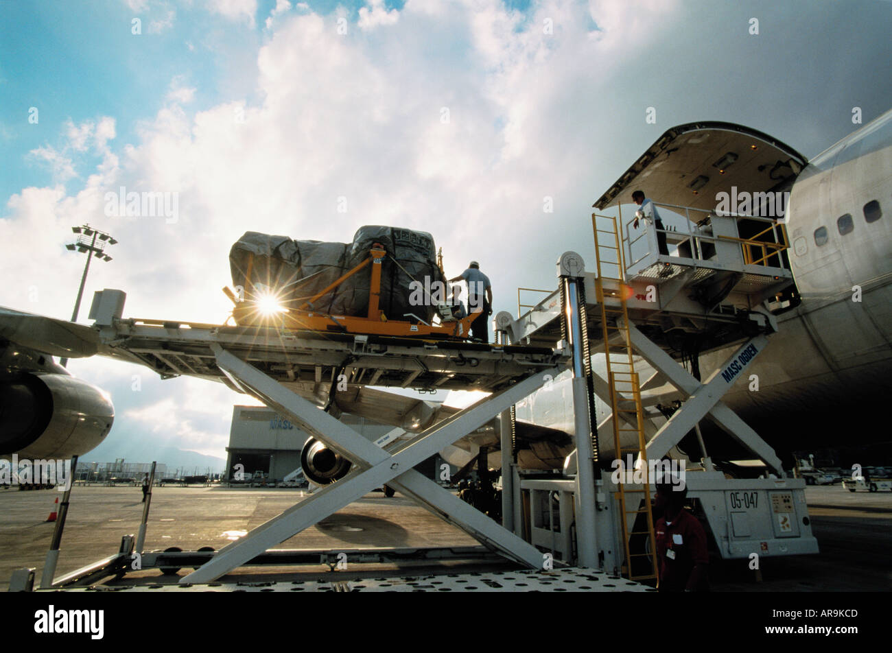 men loading Boeing 747 jumbo jet unloading cargo freight containers ...