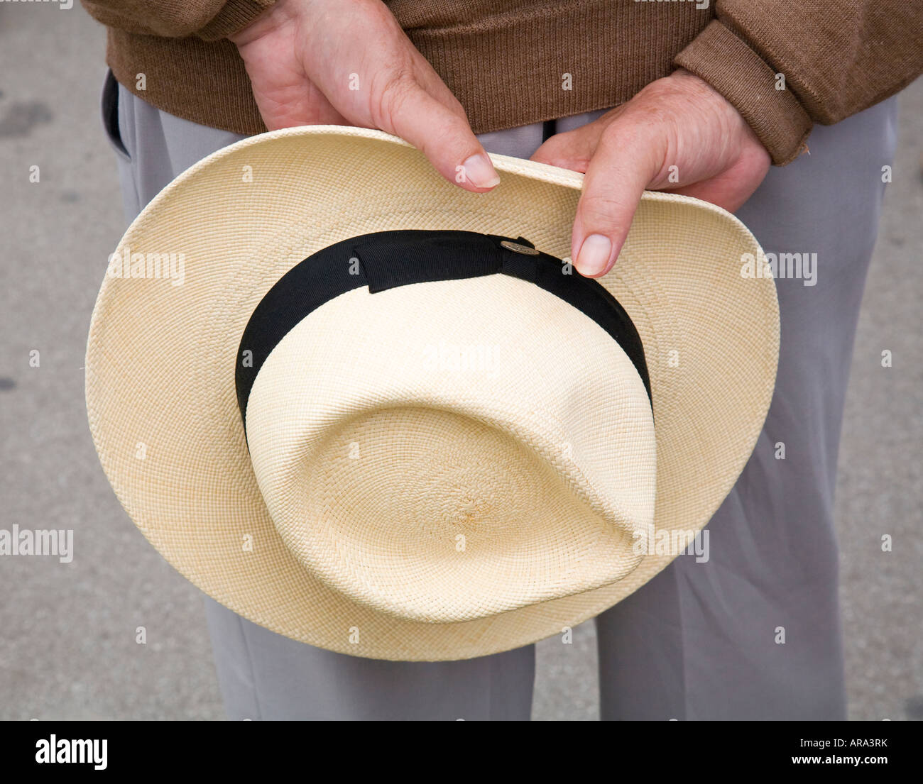 A man holding a straw hat behind his back Stock Photo - Alamy