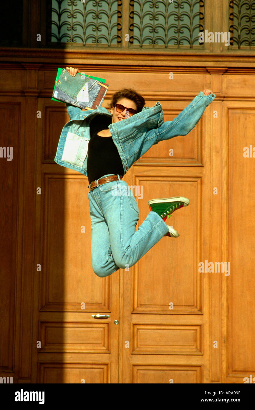 Jumping student in front of door Stock Photo - Alamy