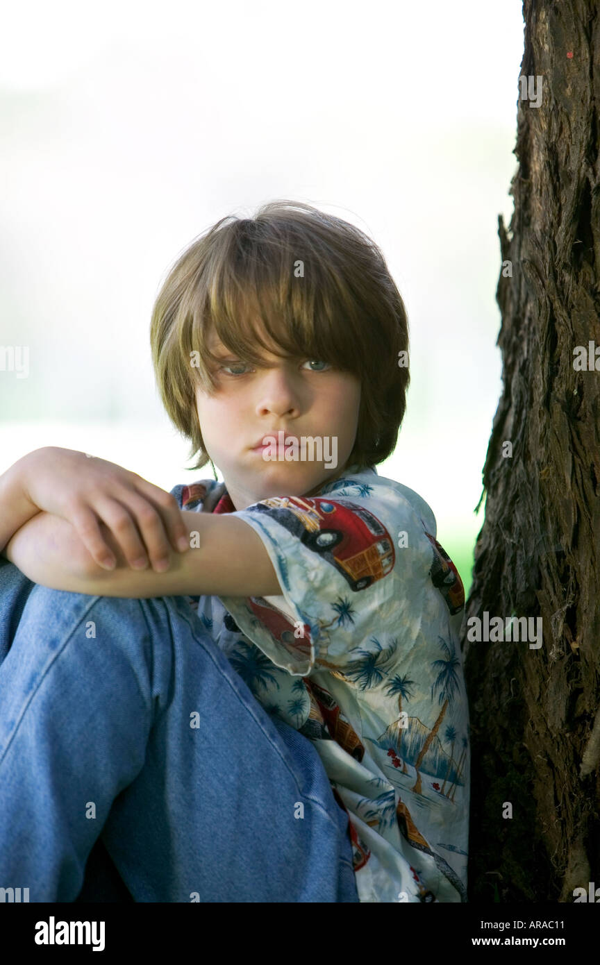 little boy sitting by tree Stock Photo - Alamy