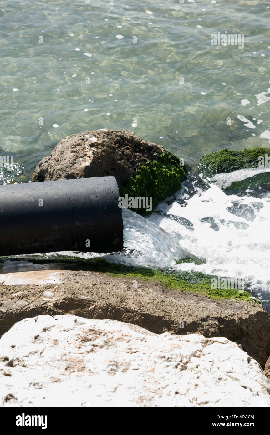 sewage flowing from a black pipe into the sea Stock Photo - Alamy
