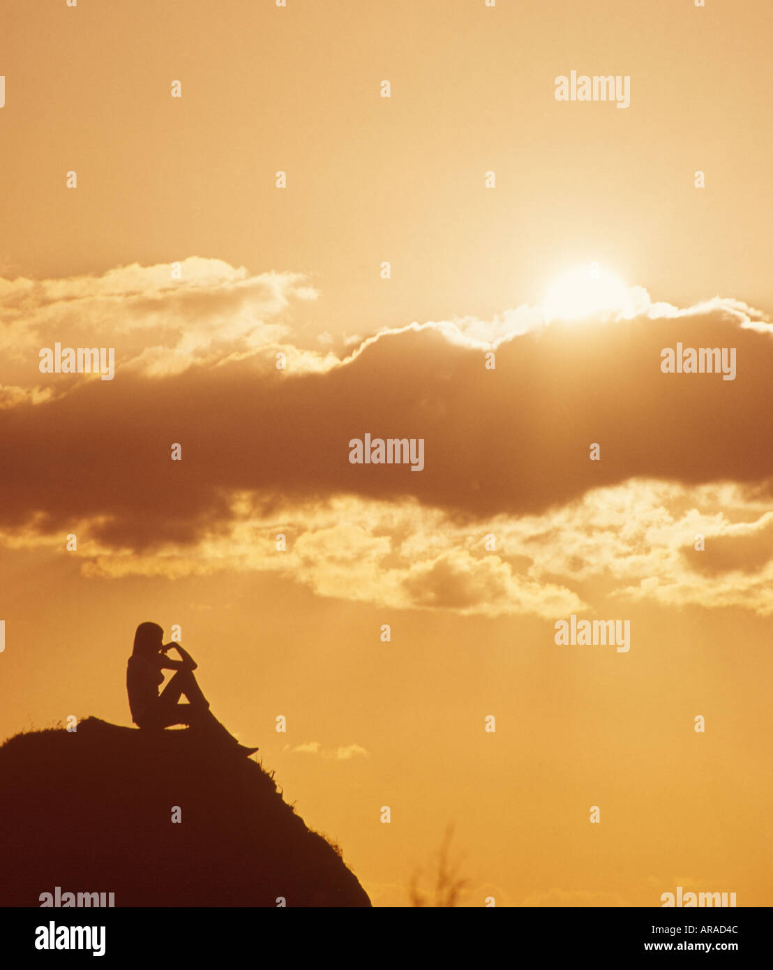 hippie girl relaxing alone on hilltop at sunset Stock Photo - Alamy