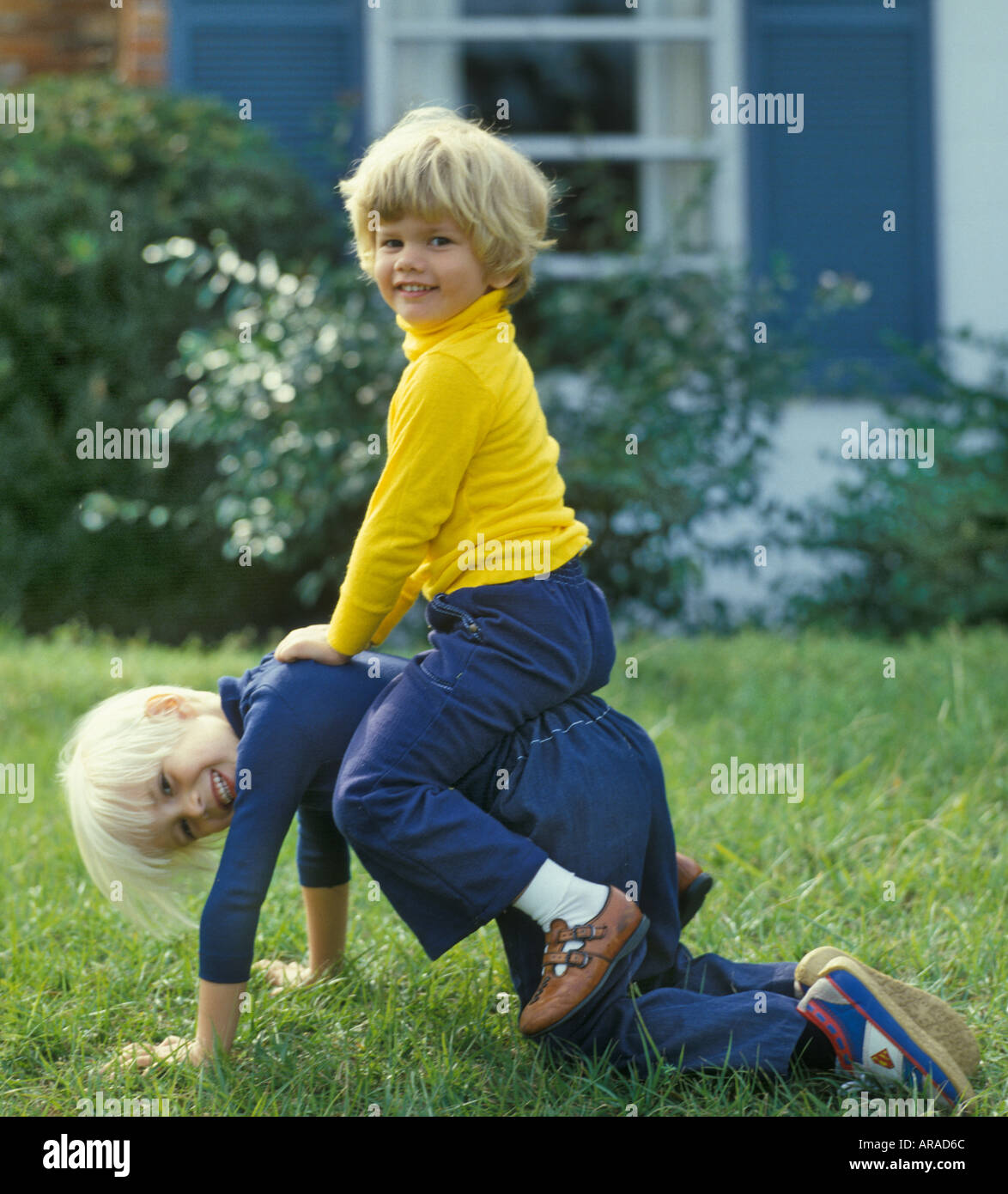 small boy and girl playing horsey in backyard Stock Photo - Alamy