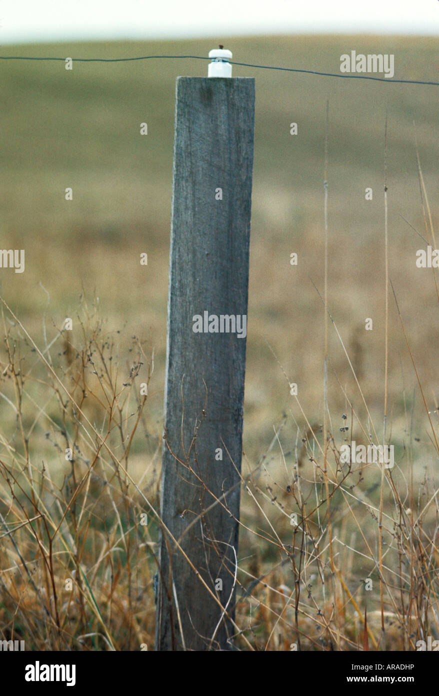 fence post w electric wire farm field Stock Photo - Alamy