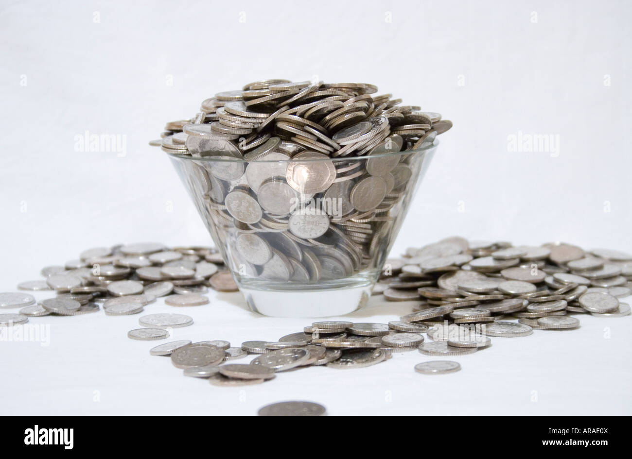 Silver coins in glass bowl Stock Photo - Alamy