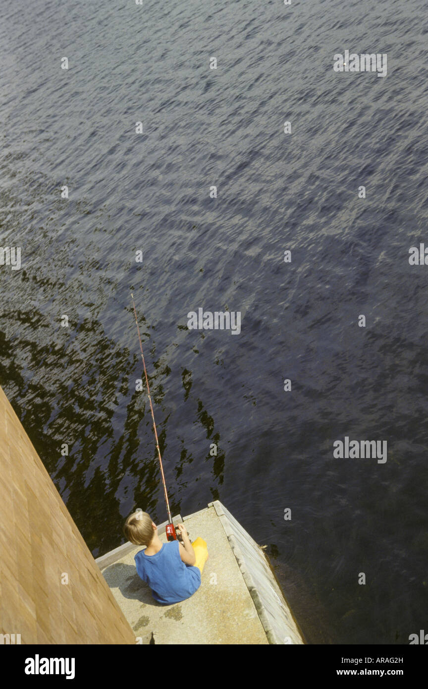 Young teenage boy fishing off dock Stock Photo - Alamy