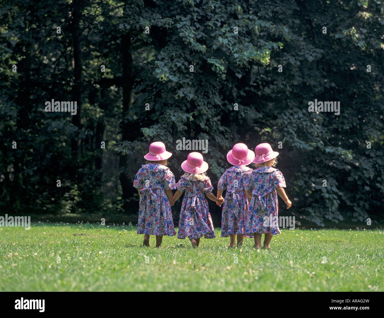 4 girls in a row with pink hats backview Stock Photo - Alamy