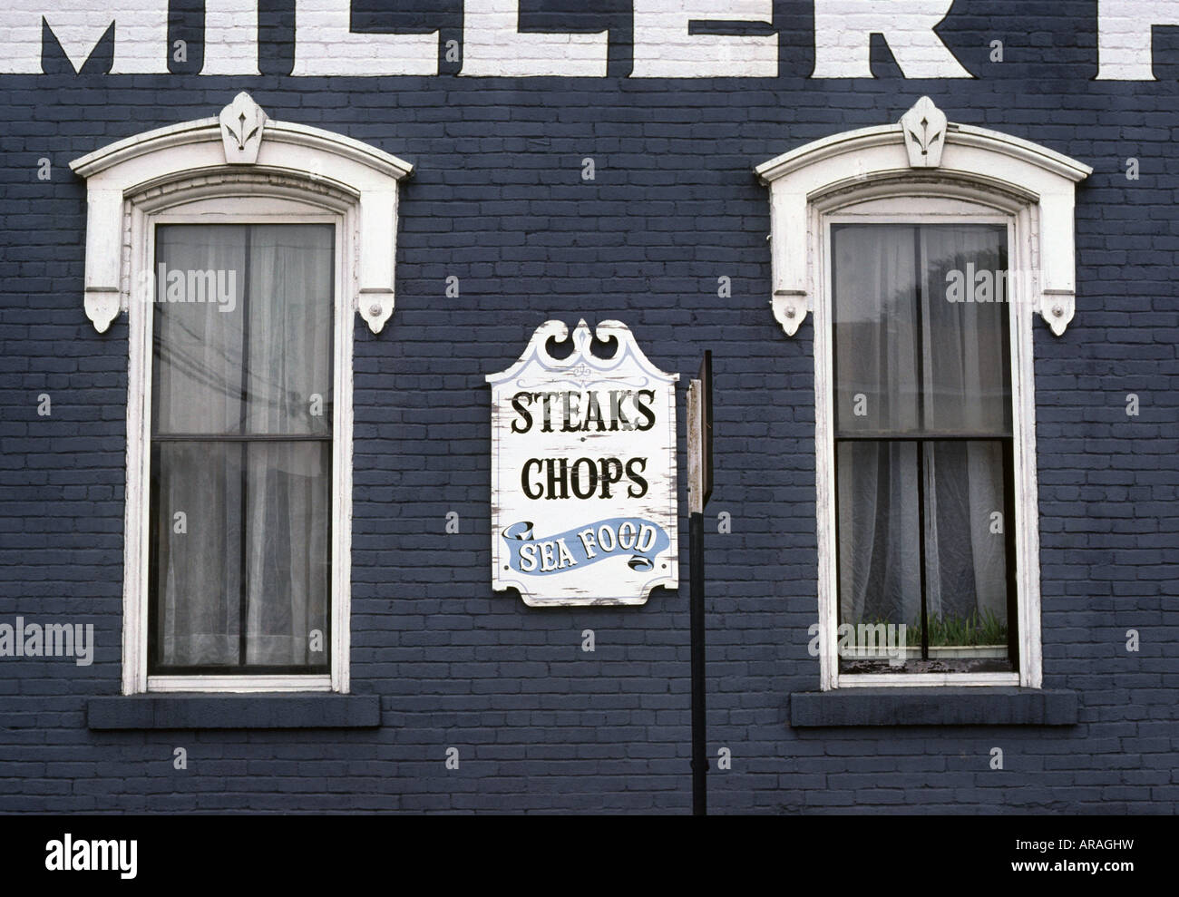 Hotel wall with classic window and table in small town Stock Photo - Alamy