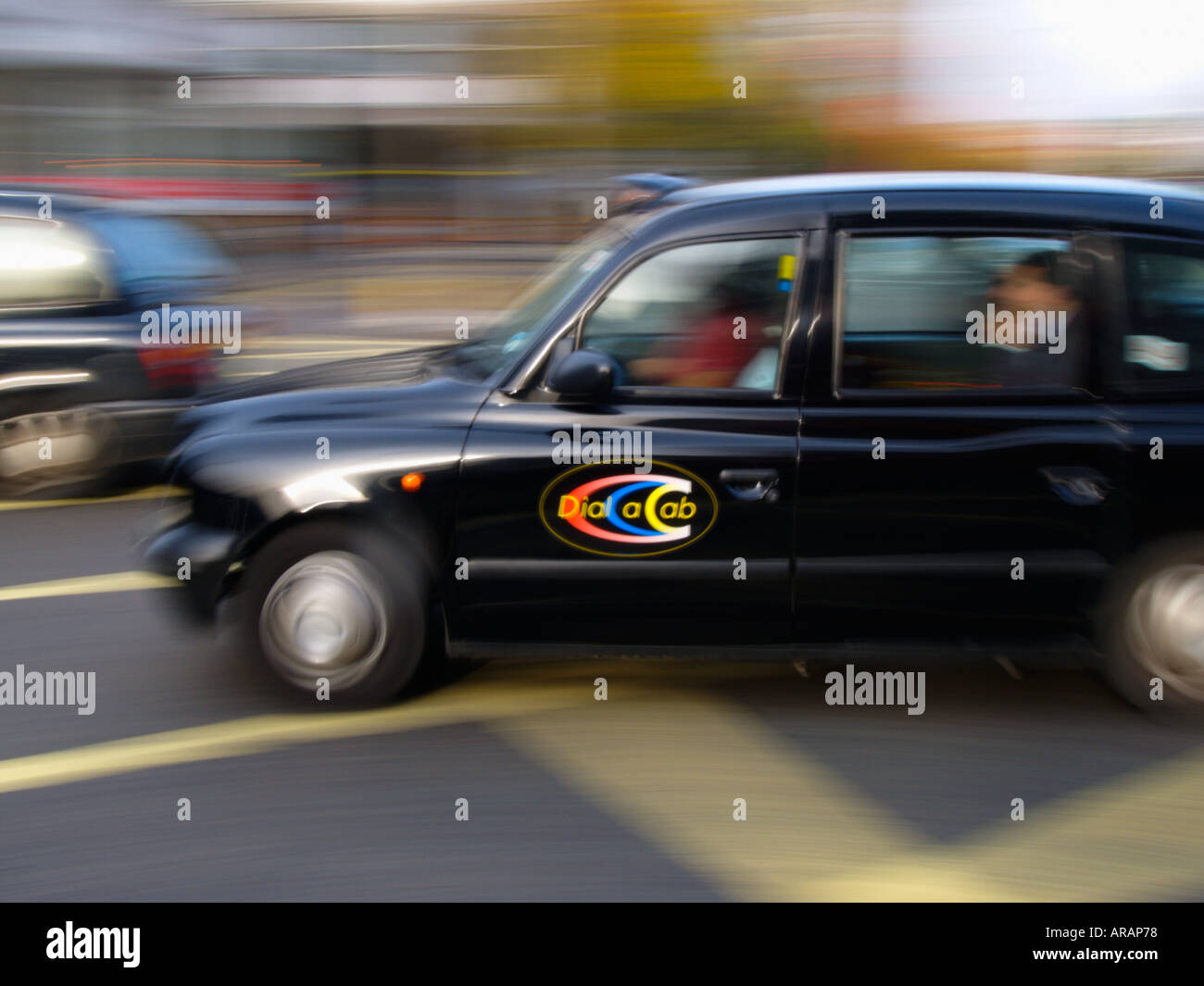 Motion blurred shot of black London taxi with dial a cab logo UK Stock ...