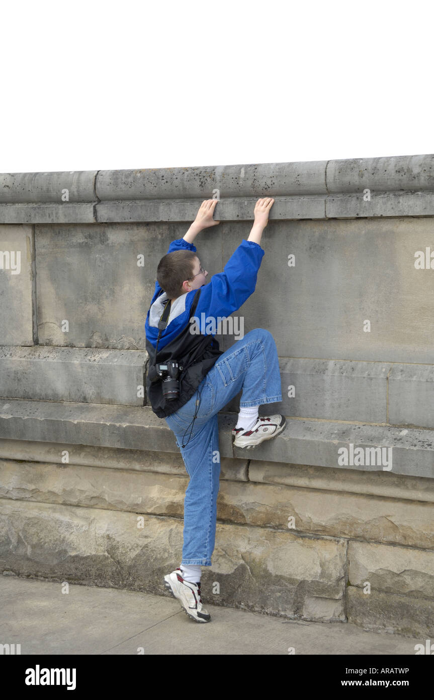 Boy climbing over wall hi-res stock photography and images - Alamy