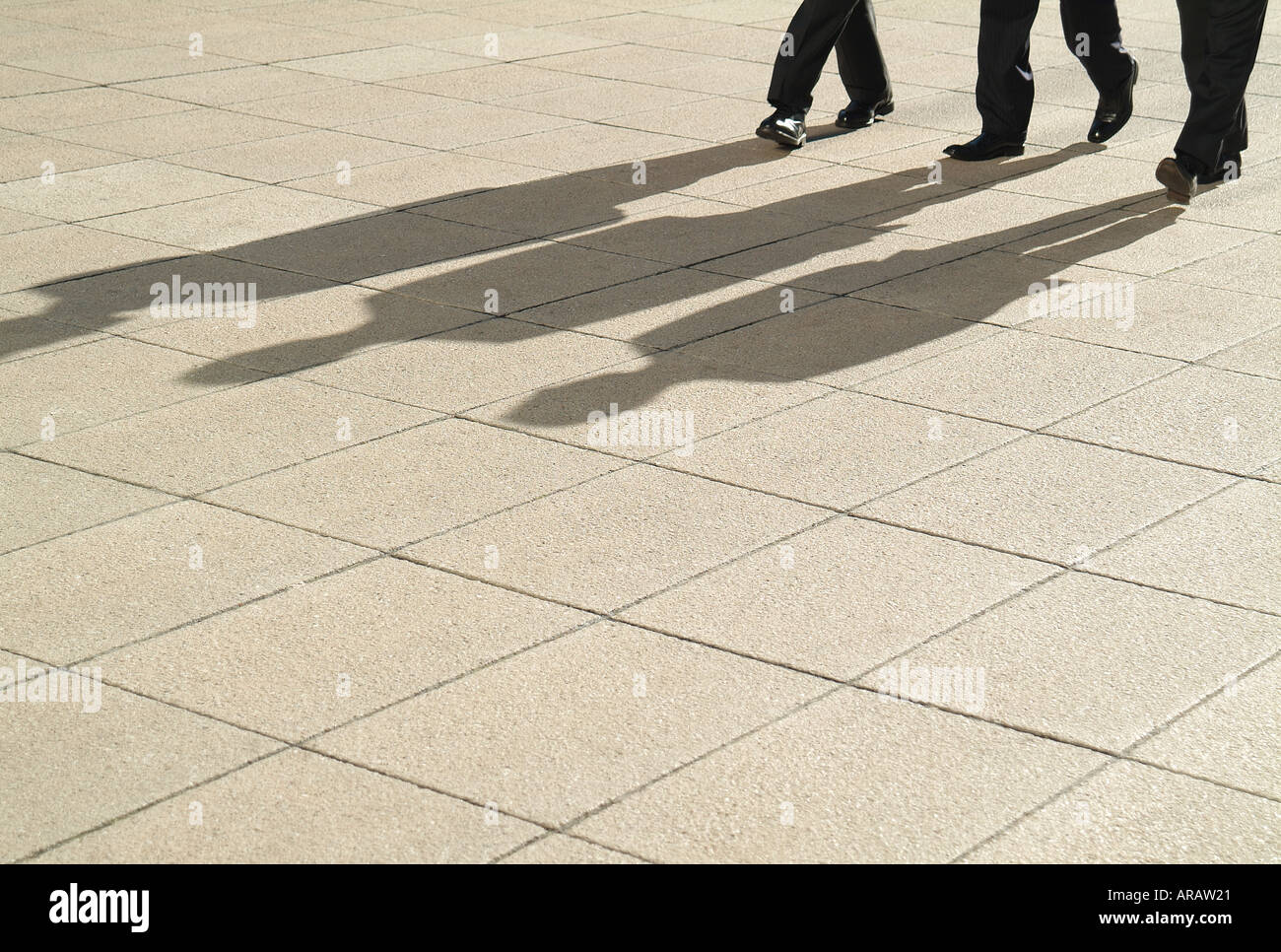 shadows of three businessmen walking on pavement Stock Photo - Alamy