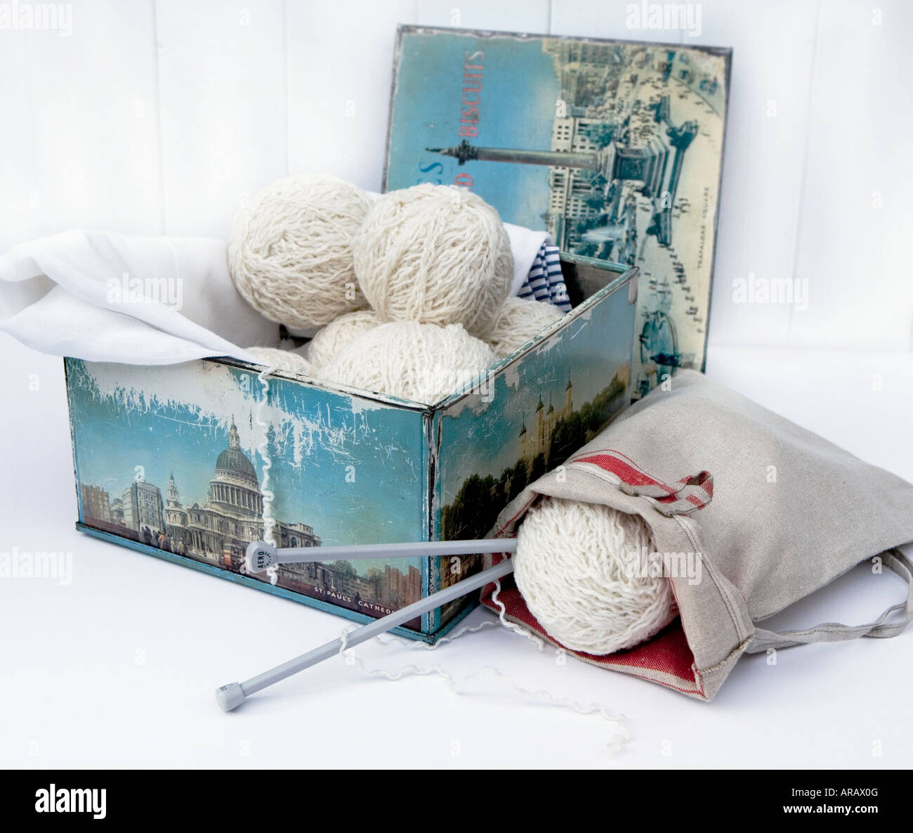Balls of wool in a vintage tin with a linen sewing bag and knitting ...