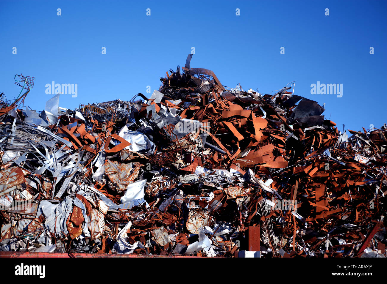 Scrap iron waiting for recycling is piled against a blue sky Stock ...