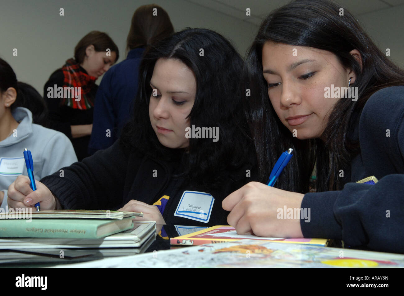 Volunteers catalog books for a children s library in a homeless shelter ...