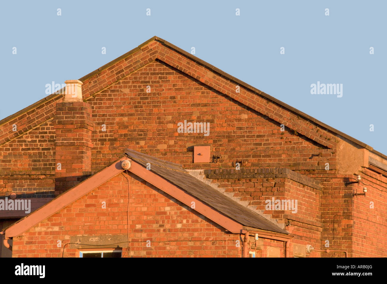An old red brick building lit by the evening sun Stock Photo - Alamy
