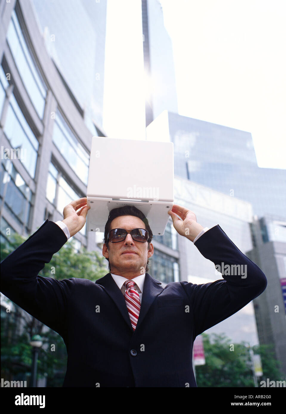 Businessman Holding Laptop Computer on Head Stock Photo - Alamy