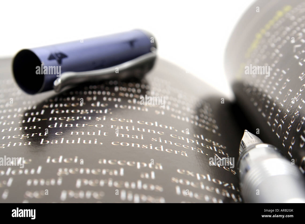 Pen on a black book isolated on white Stock Photo - Alamy