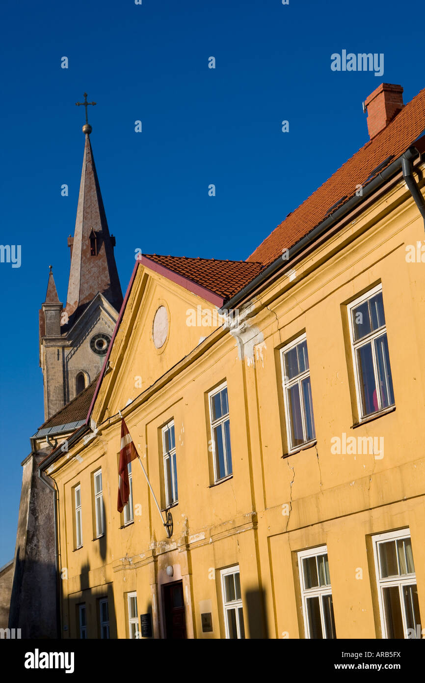 The spire of St. John's Church rises above an office building in Cesis ...