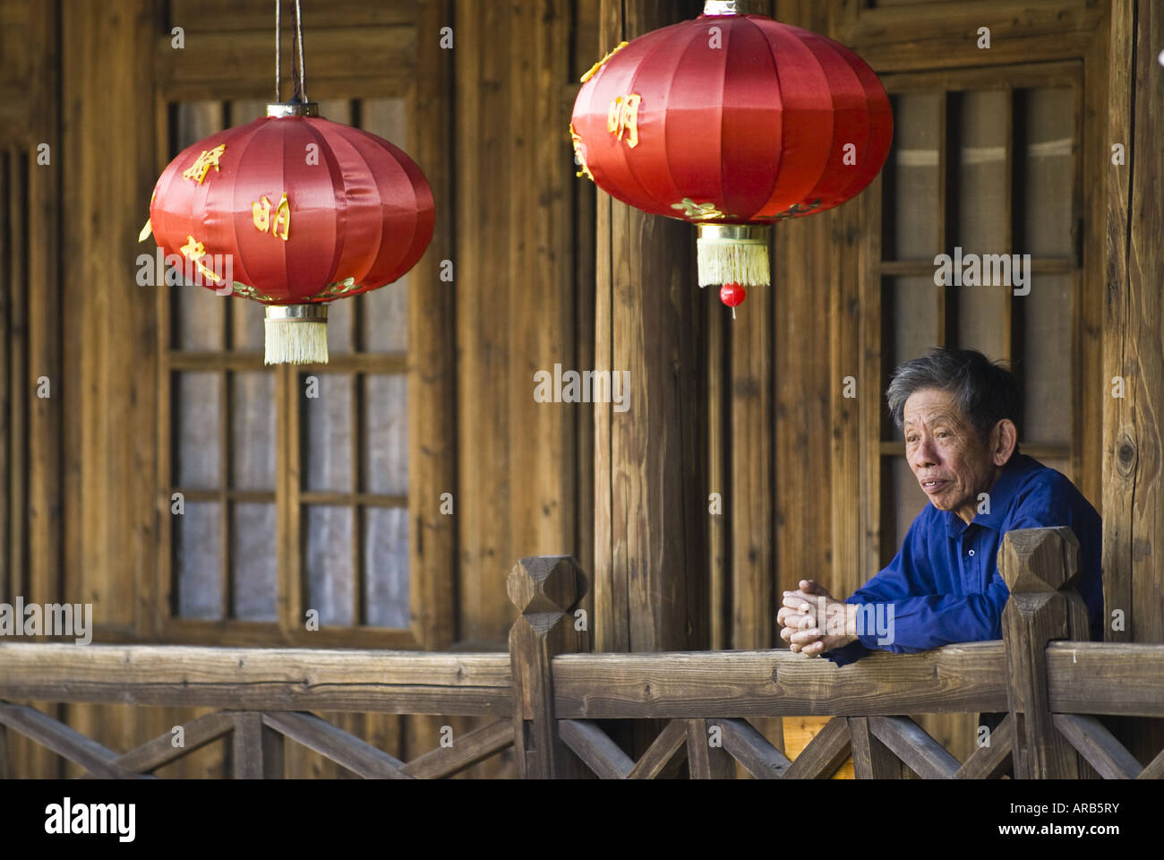 Man on interior balcony of traditional rammed earth living complex ...