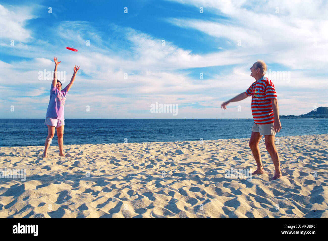 Senior couple tossing frisbee on beach at Cabo San Lucas Mexico Stock ...
