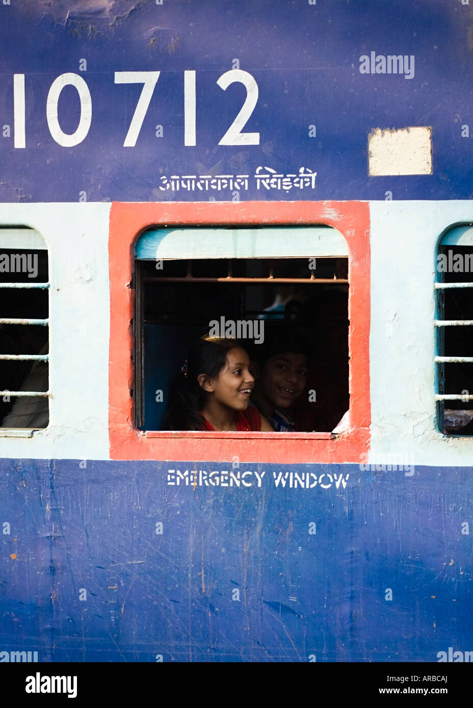 Emergency window of a blue indian train with two passengers at the Old ...