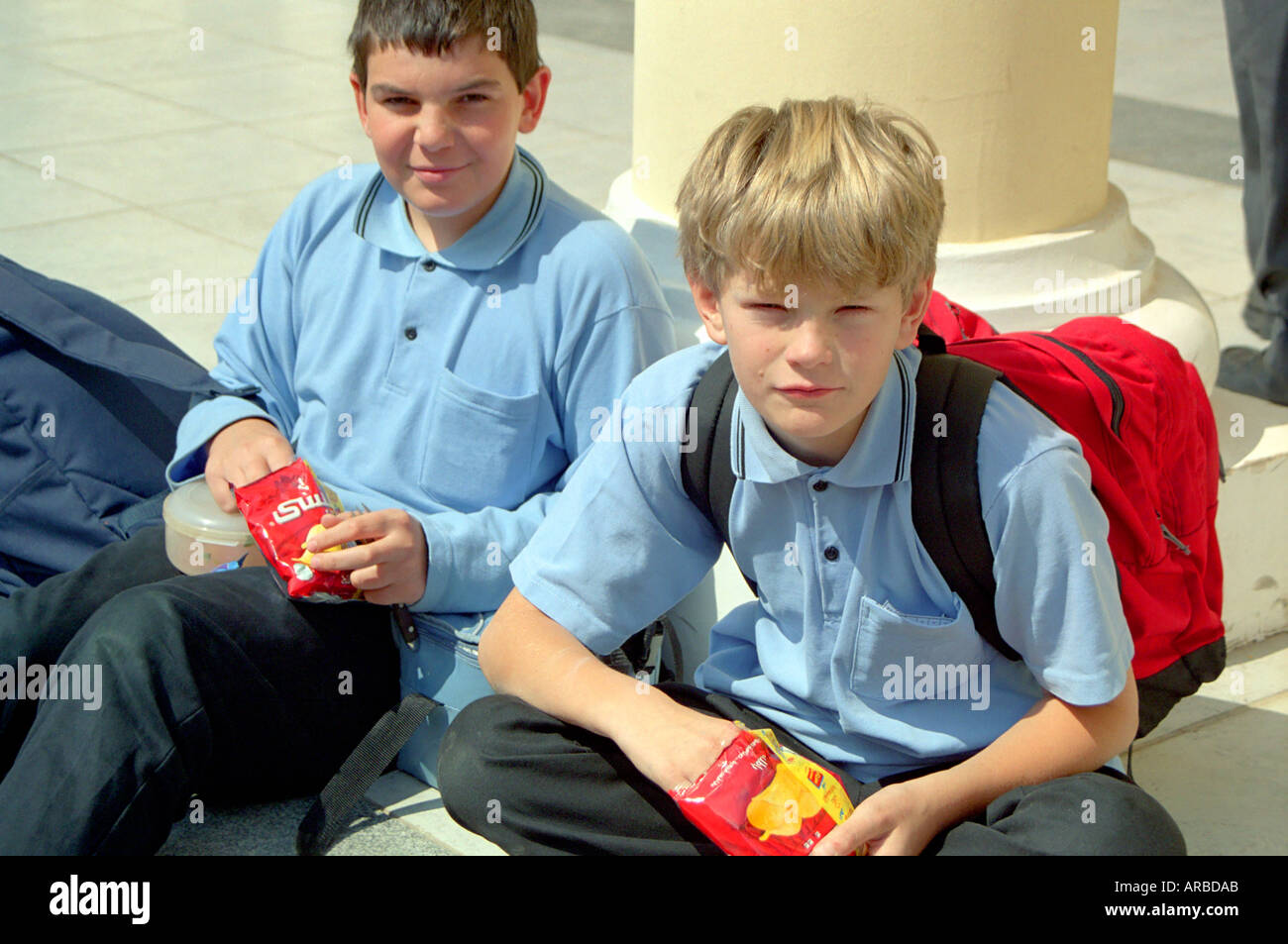 school boys sitting outside eating crisps Stock Photo - Alamy