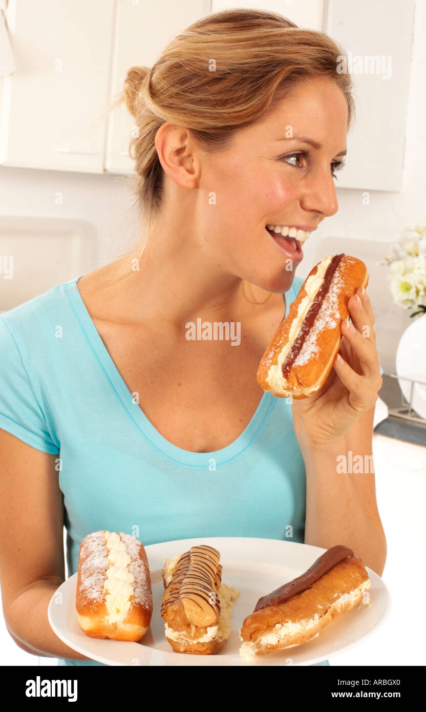 WOMAN EATING CREAM CAKES AND CREAM DOUGHNUTS Stock Photo - Alamy