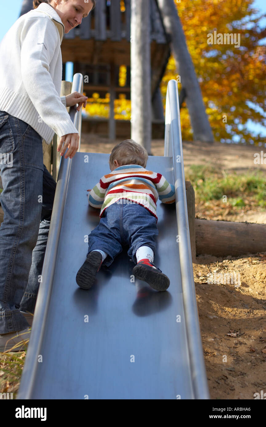 baby sliding down the slide on the playground Stock Photo - Alamy