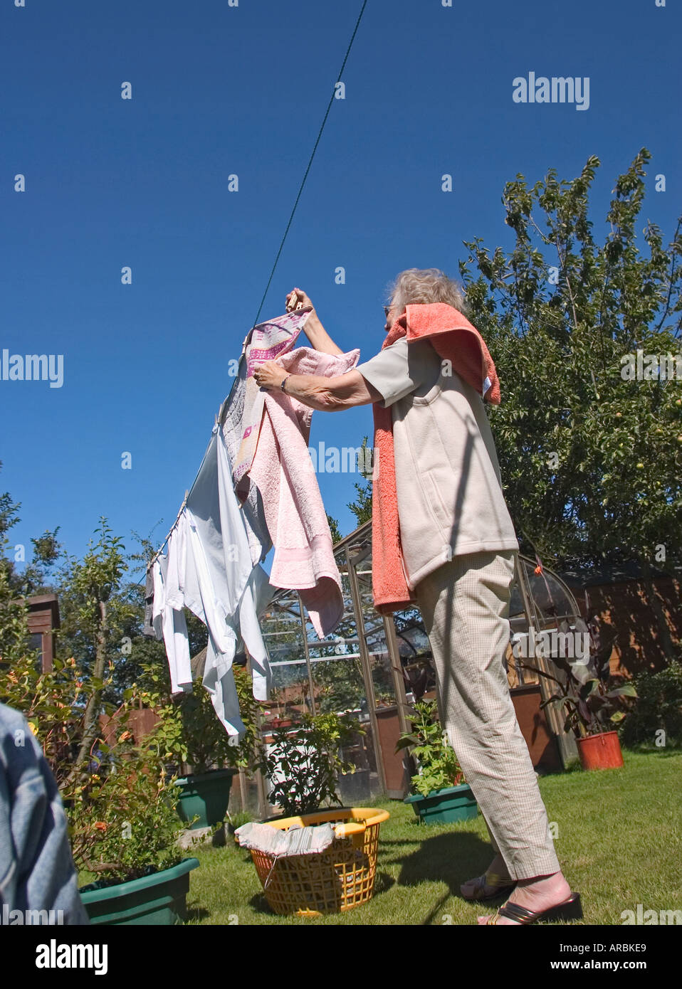 Elderley lady hanging out the washing Stock Photo - Alamy