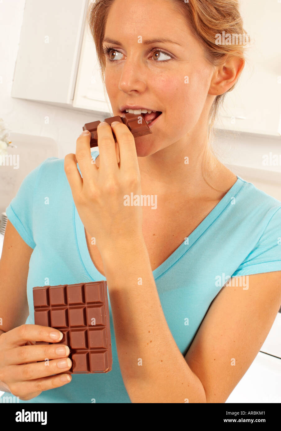 GIRL EATING BAR OF CHOCOLATE Stock Photo - Alamy