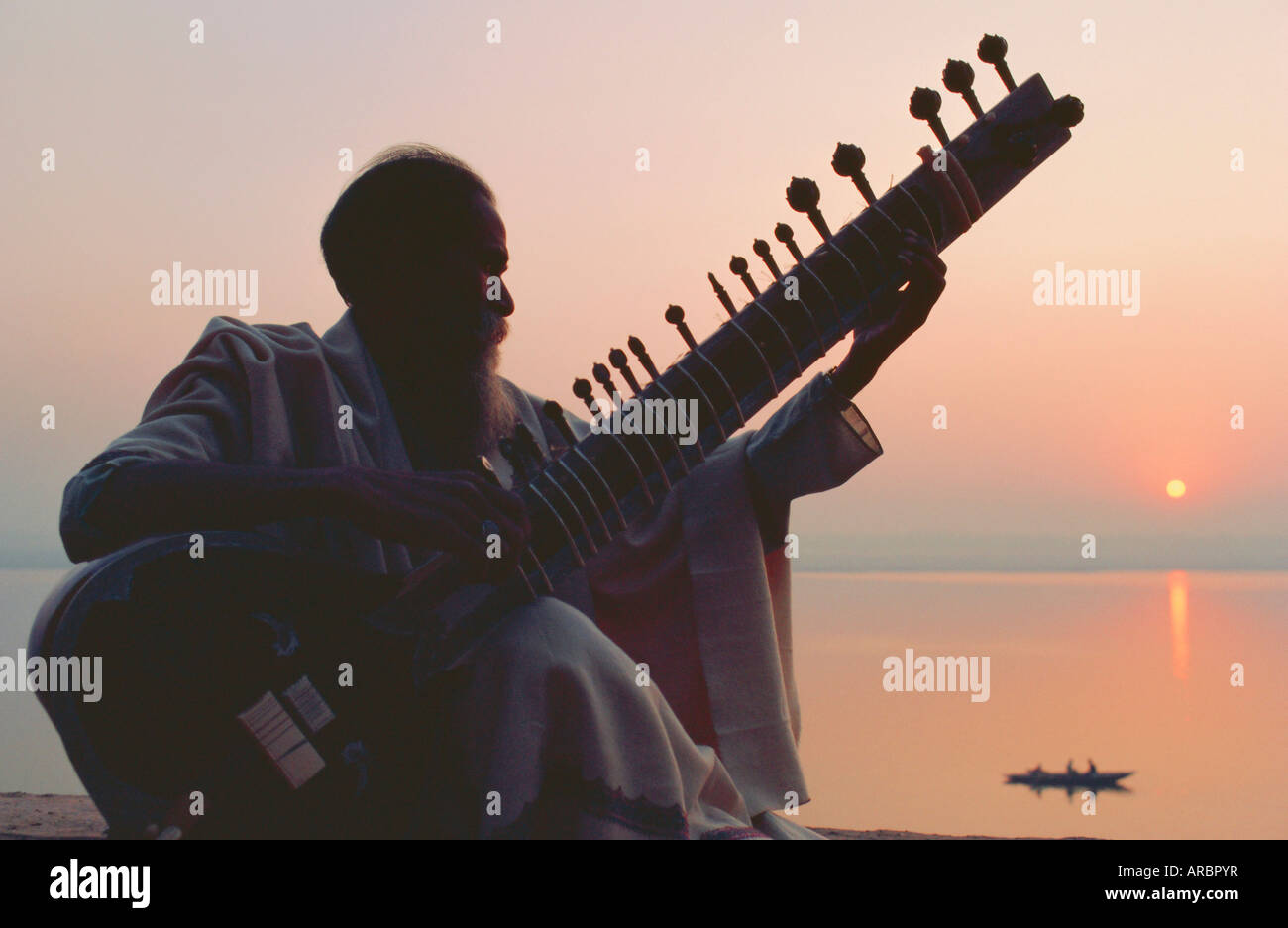 Elderly man playing the sitar beside the Ganges (Ganga) River, Varanasi ...