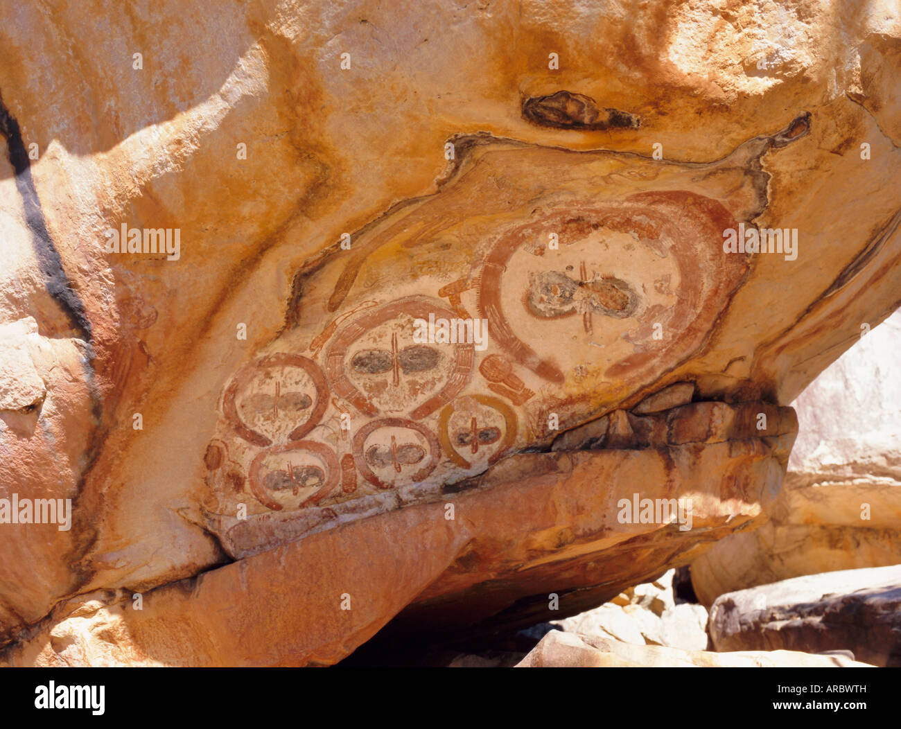 Group of Wandjana 'faces' on shaded underside of rock, Kulumburu Road ...